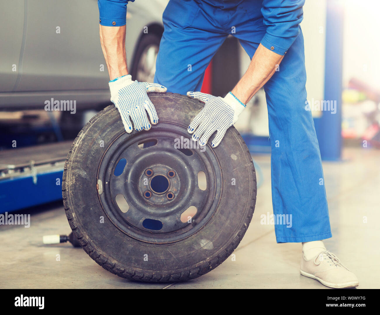 mechanic with wheel tire at car workshop Stock Photo - Alamy