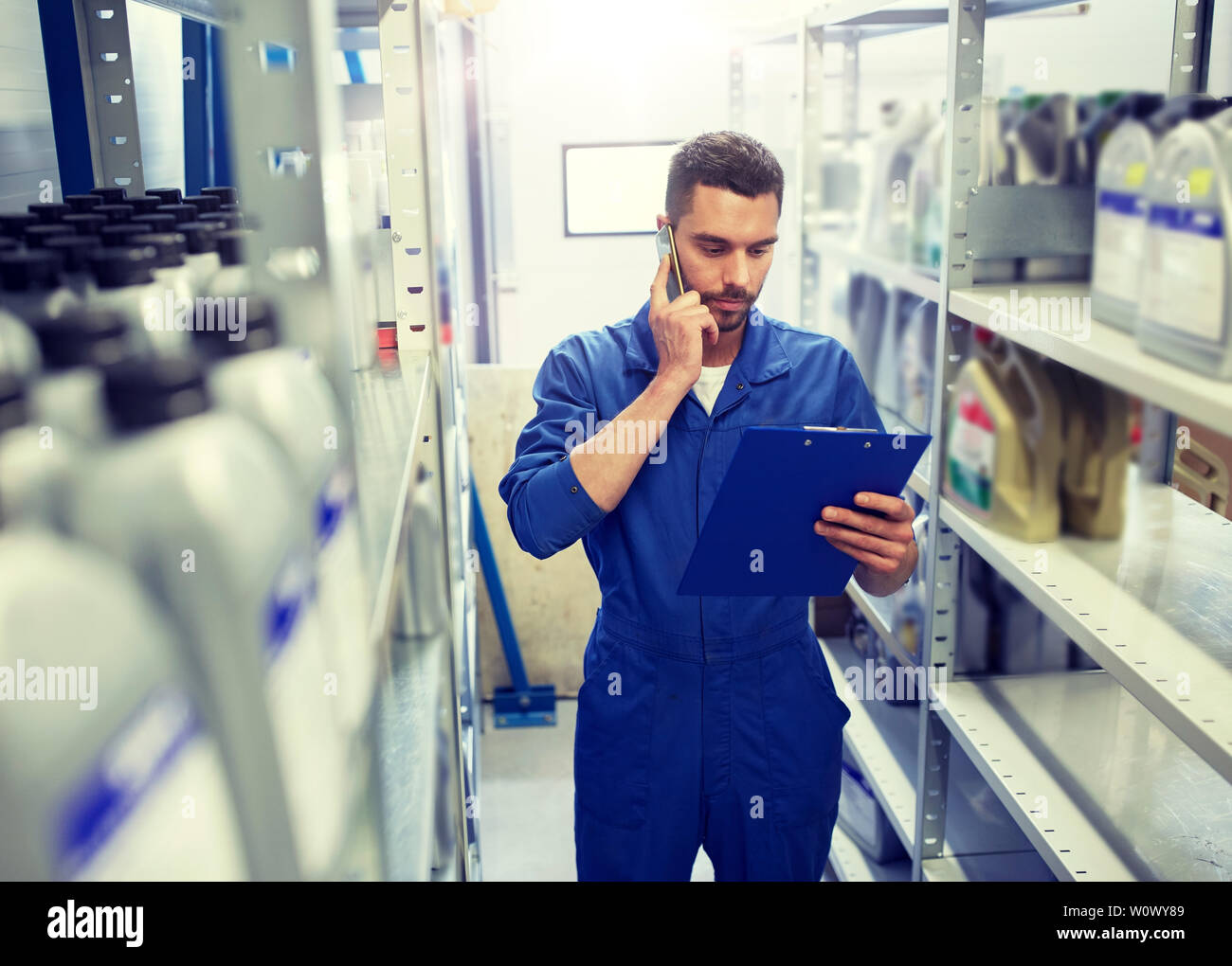 auto mechanic calling on smartphone at car shop Stock Photo - Alamy