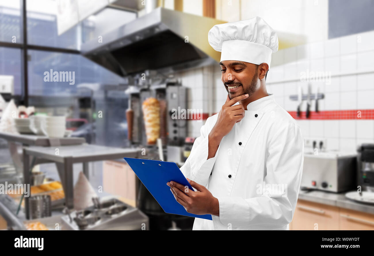 indian chef with menu on clipboard at kebab shop Stock Photo - Alamy