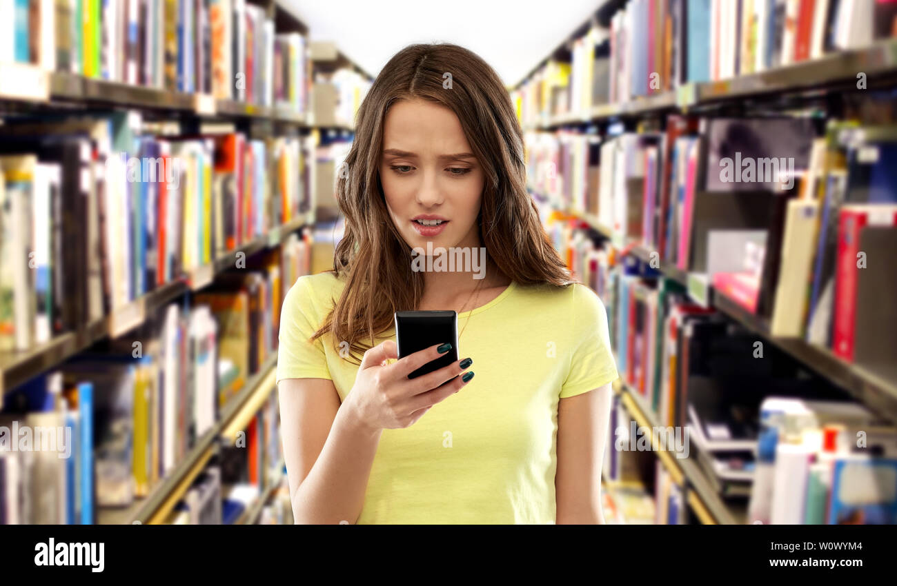 teenage student girl using smartphone at library Stock Photo - Alamy