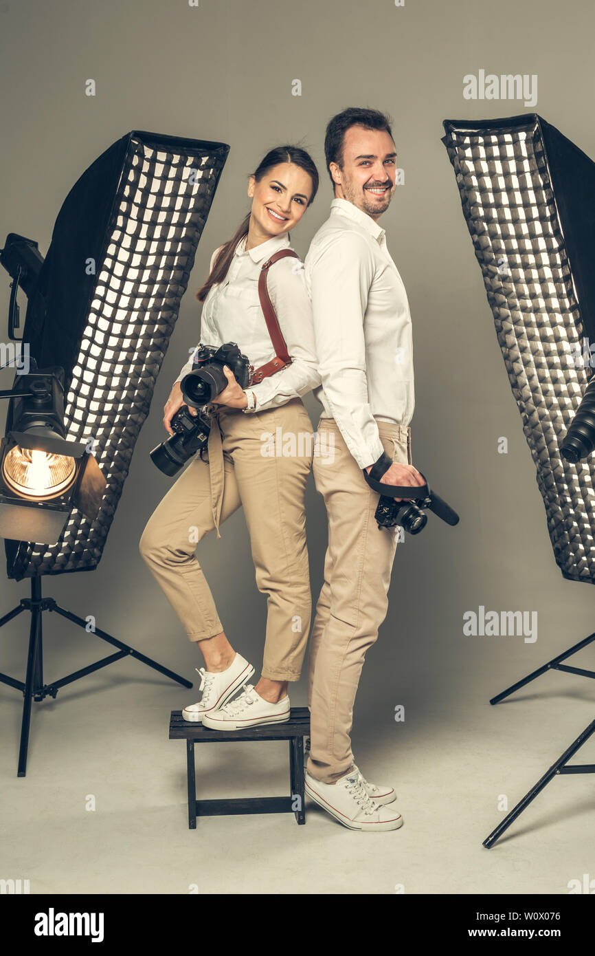 Smiling young professional photographers posing in the studio Stock ...