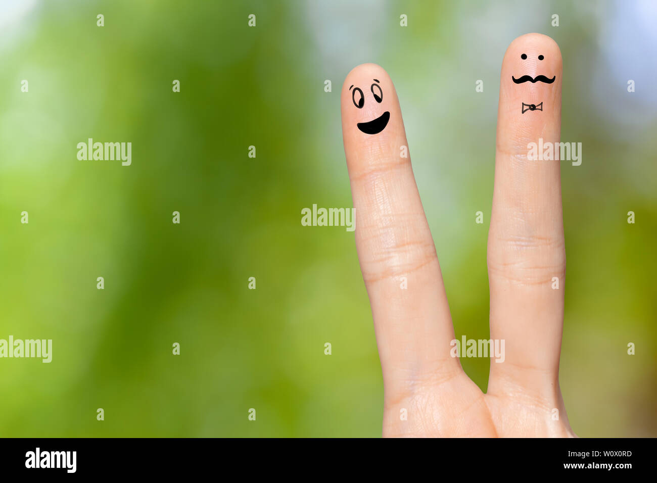Human hand fingers with funny painted emoticons. People relationships ...