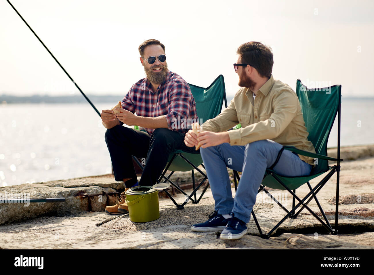 happy friends fishing and eating sandwiches Stock Photo - Alamy