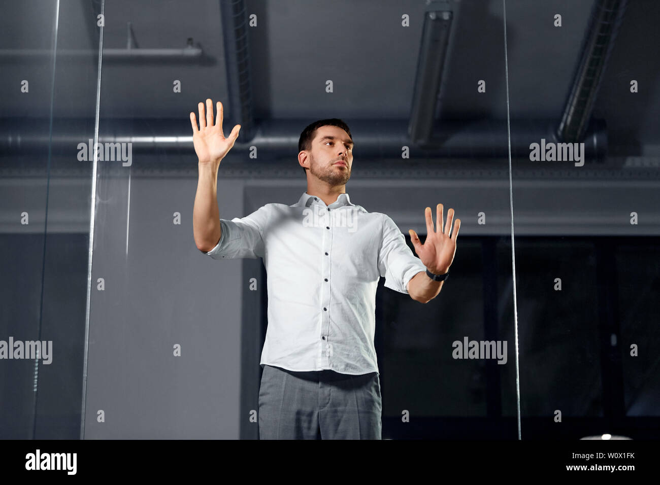 businessman touching glass wall at night office Stock Photo - Alamy