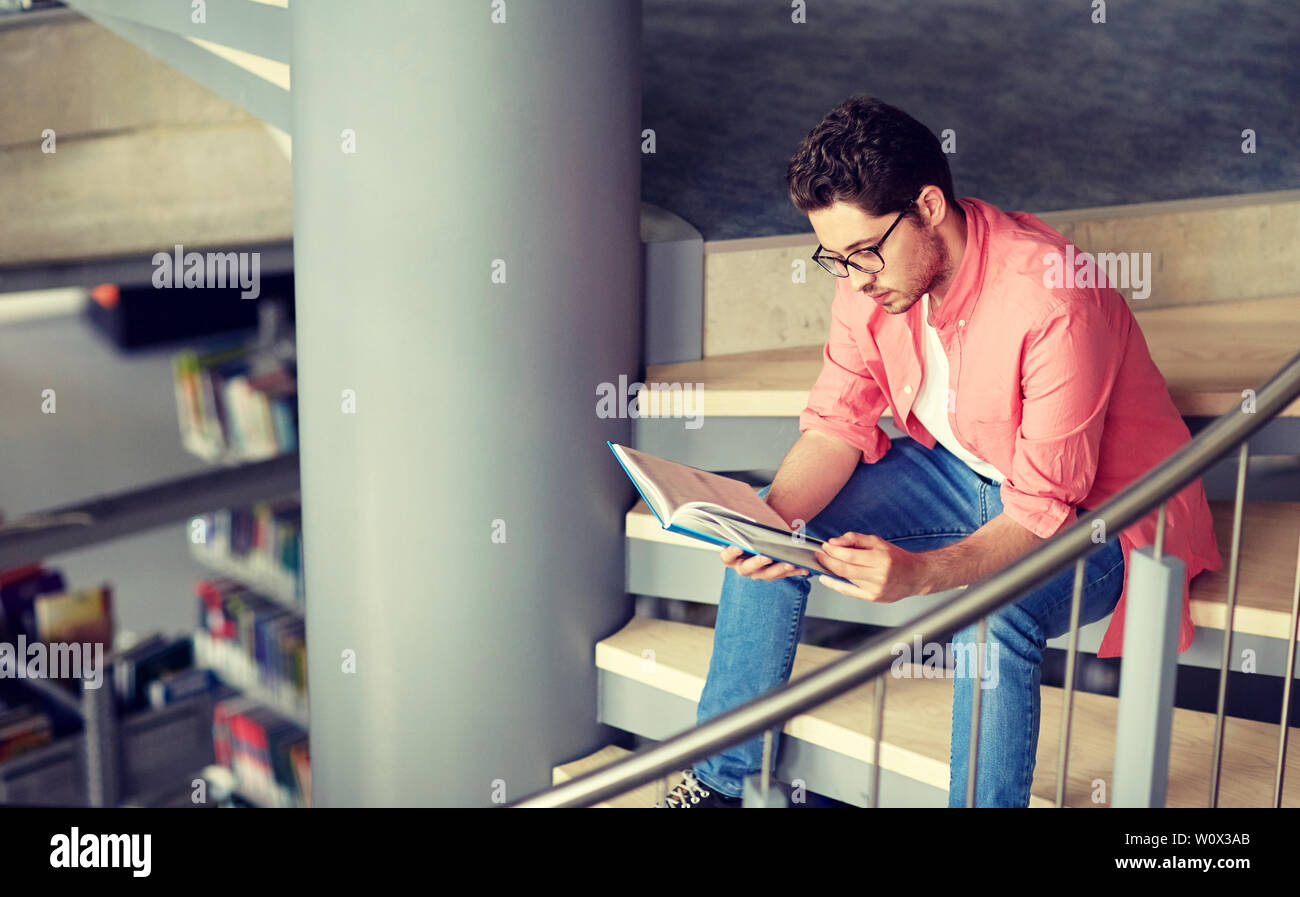 student boy or young man reading book at library Stock Photo - Alamy