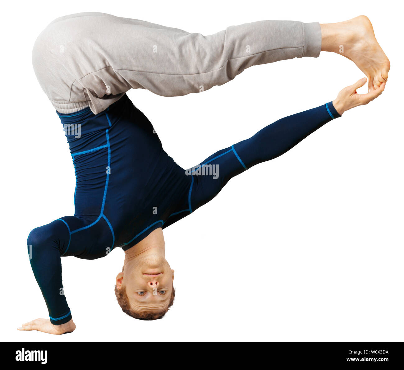 Flexible sporty young man doing stretching exercises isolated on white ...