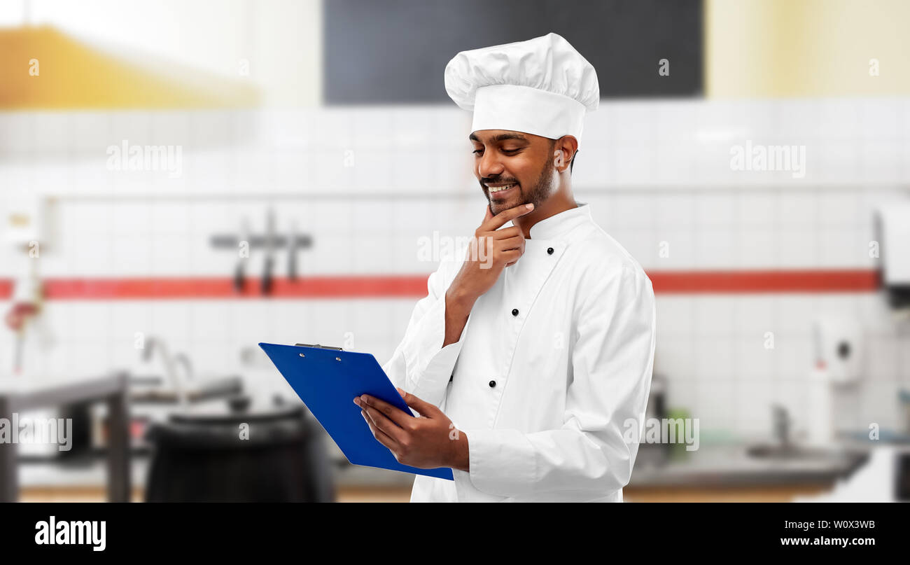 indian chef with clipboard at restaurant kitchen Stock Photo - Alamy