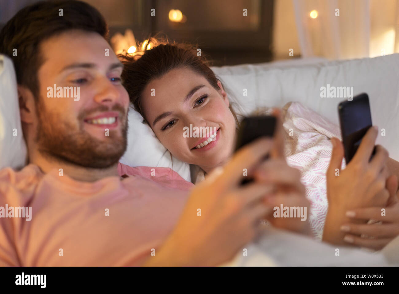 happy couple using smartphones in bed at night Stock Photo - Alamy
