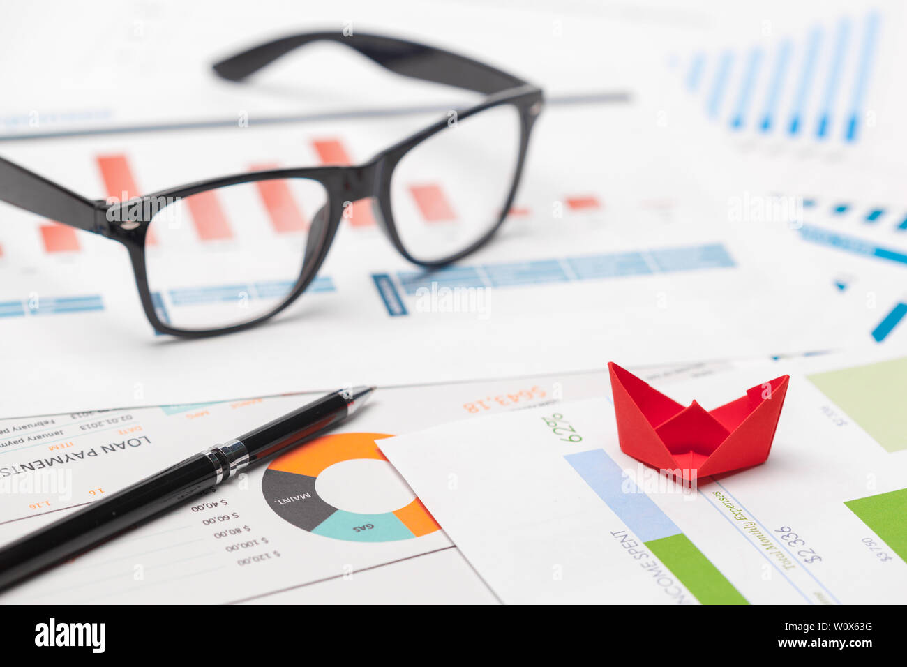 Boats made of paper graph on notebook with glasses and pen.Business ...