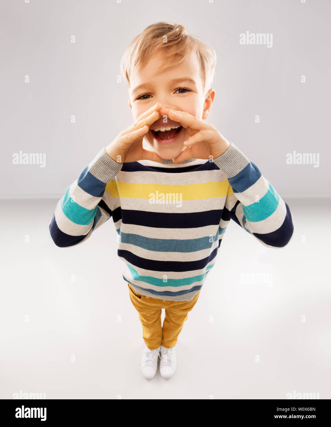 little boy in striped pullover calling someone Stock Photo - Alamy