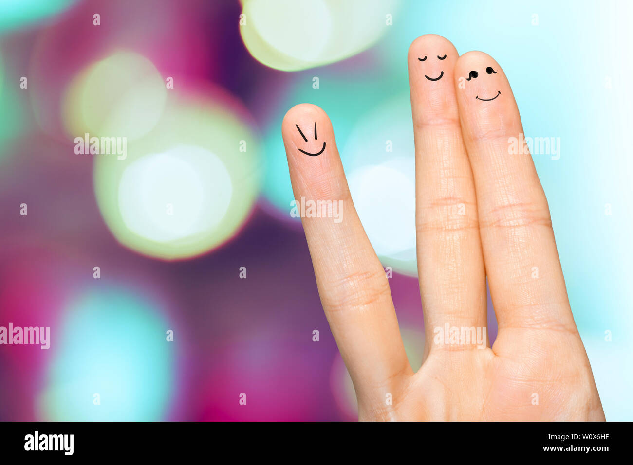 Human hand fingers with funny painted emoticons. People relationships ...