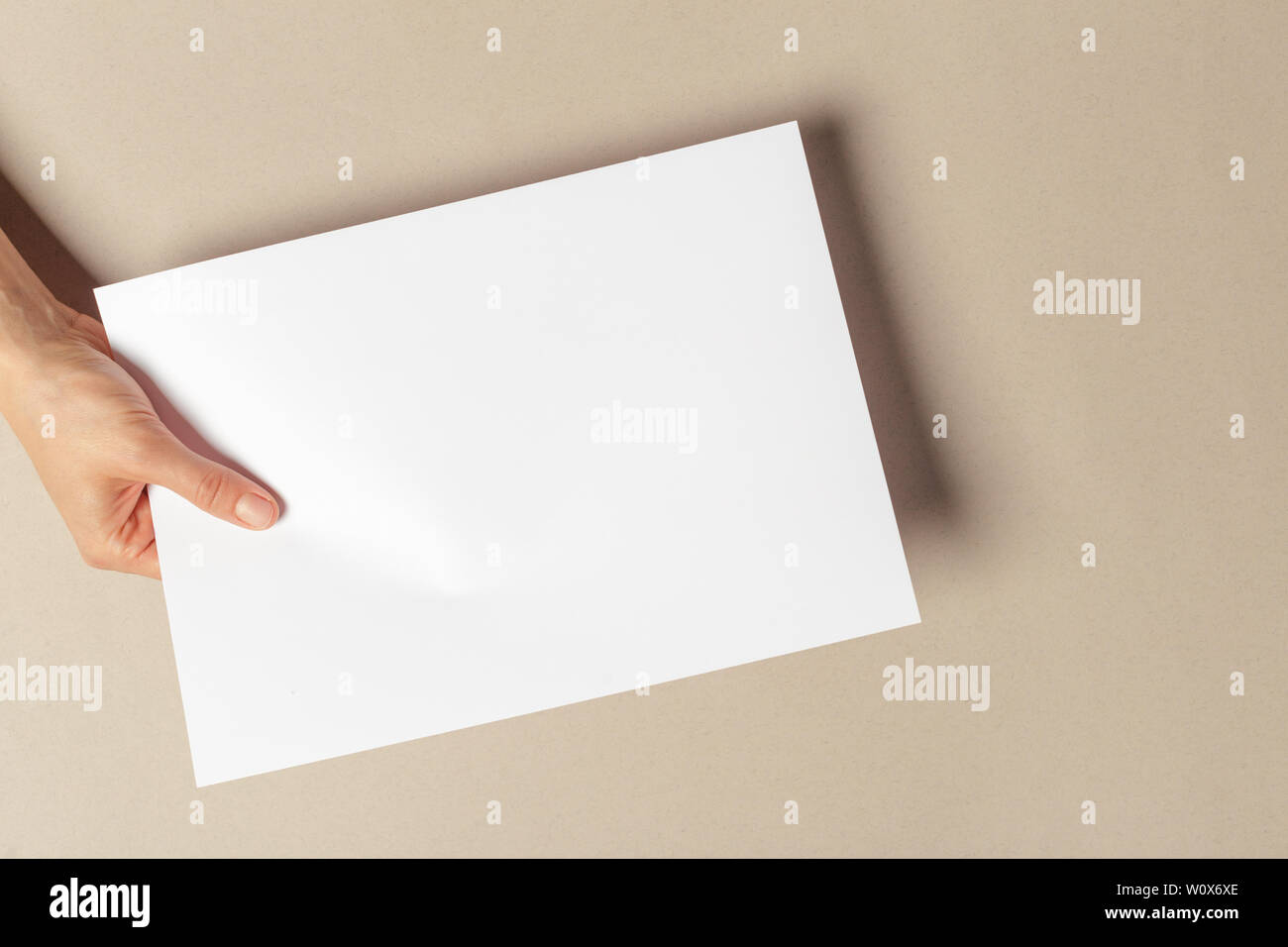 Hand holding papers a4 size Stock Photo - Alamy