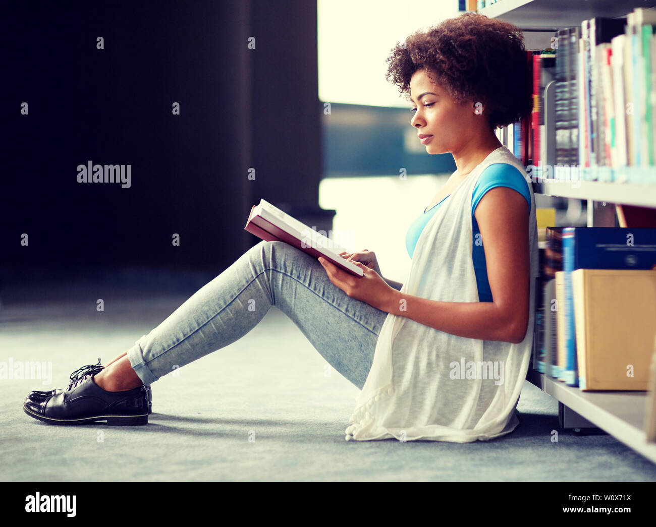 African teen reading book floor hi-res stock photography and images - Alamy