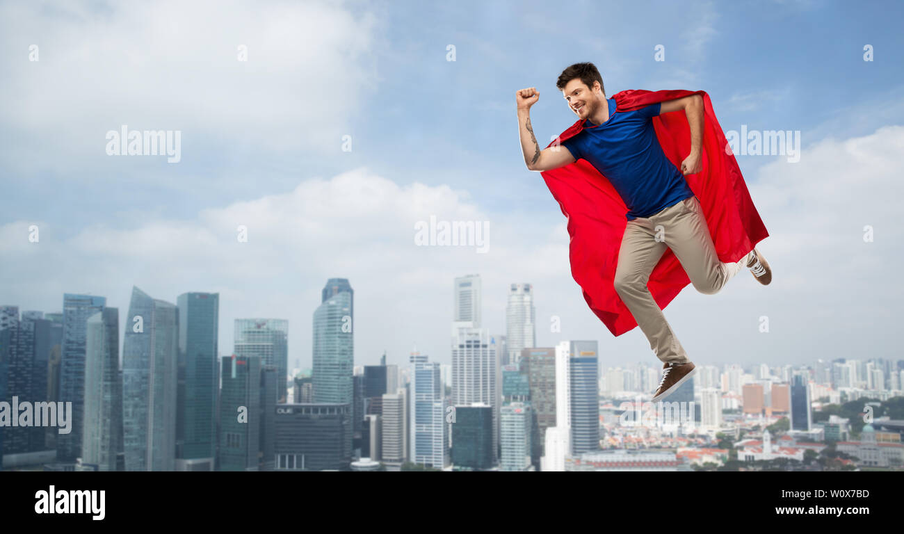 man in red superhero cape flying in air over city Stock Photo - Alamy