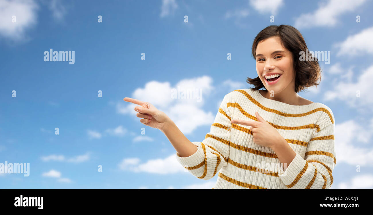 happy woman pointing fingers to something over sky Stock Photo - Alamy