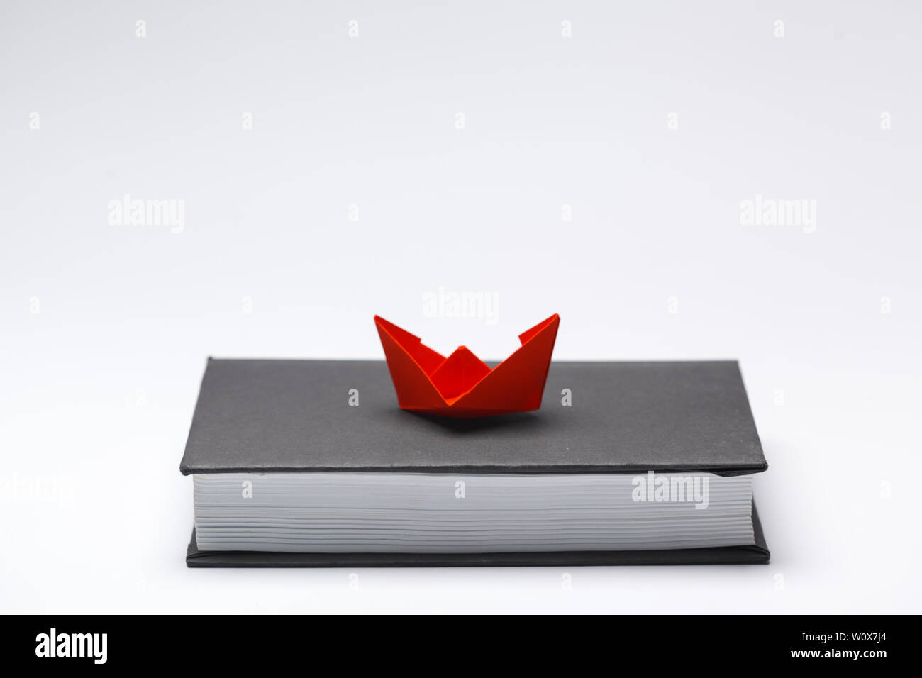 Origami paper boat on a book Stock Photo - Alamy