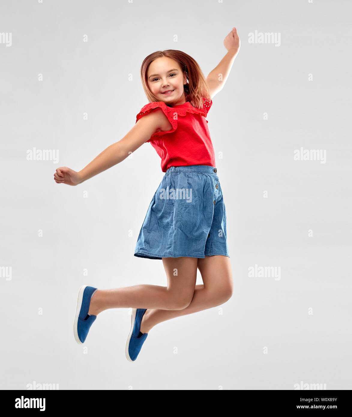 happy smiling girl in red shirt and skirt jumping Stock Photo - Alamy