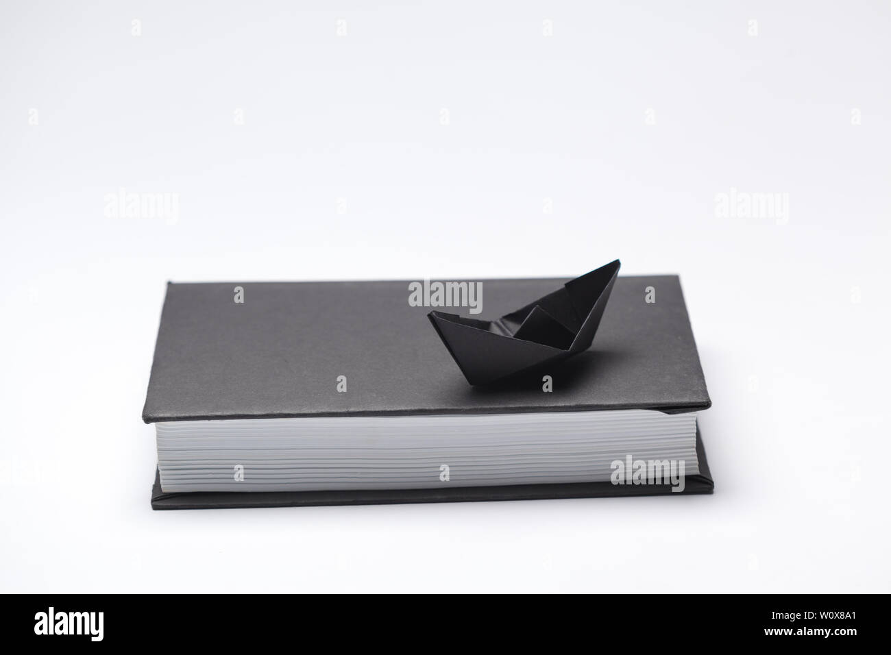 Origami paper boat on a book Stock Photo - Alamy
