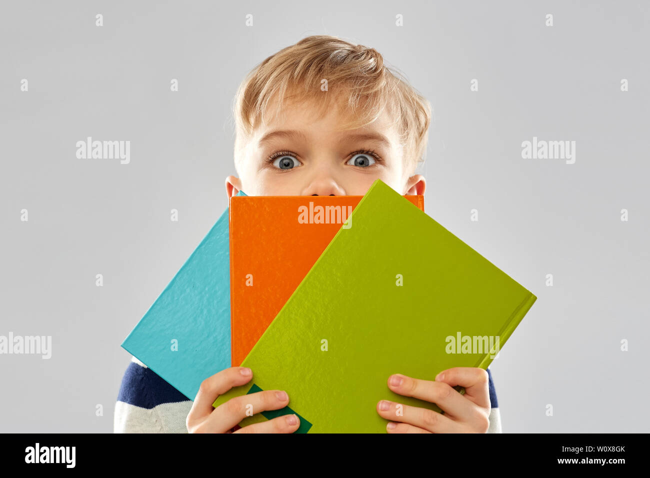 shy schoolboy hiding behind books Stock Photo - Alamy