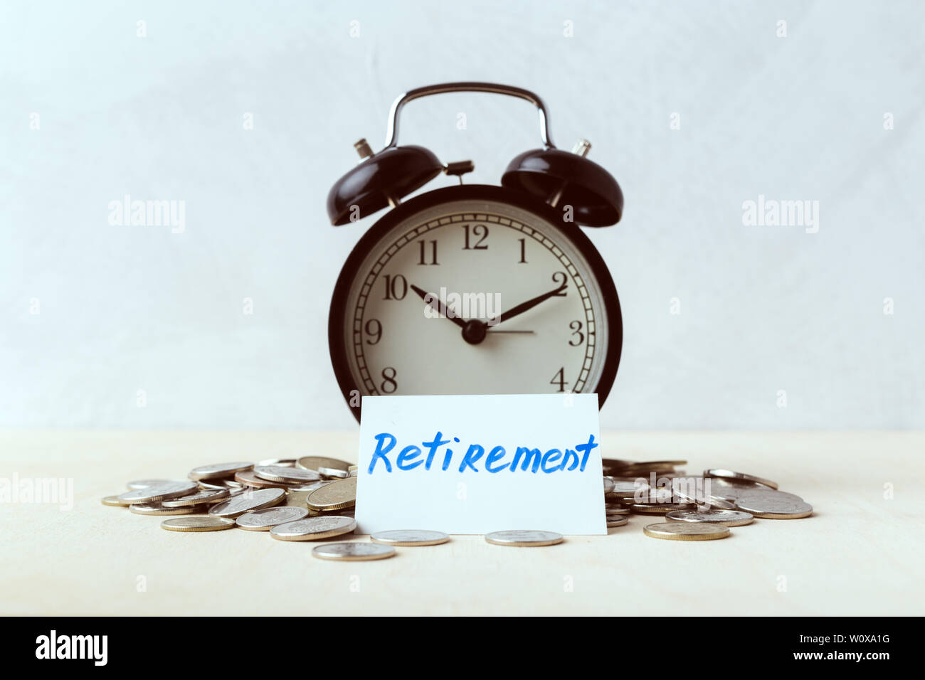 Time is money, table clock with coins Stock Photo - Alamy