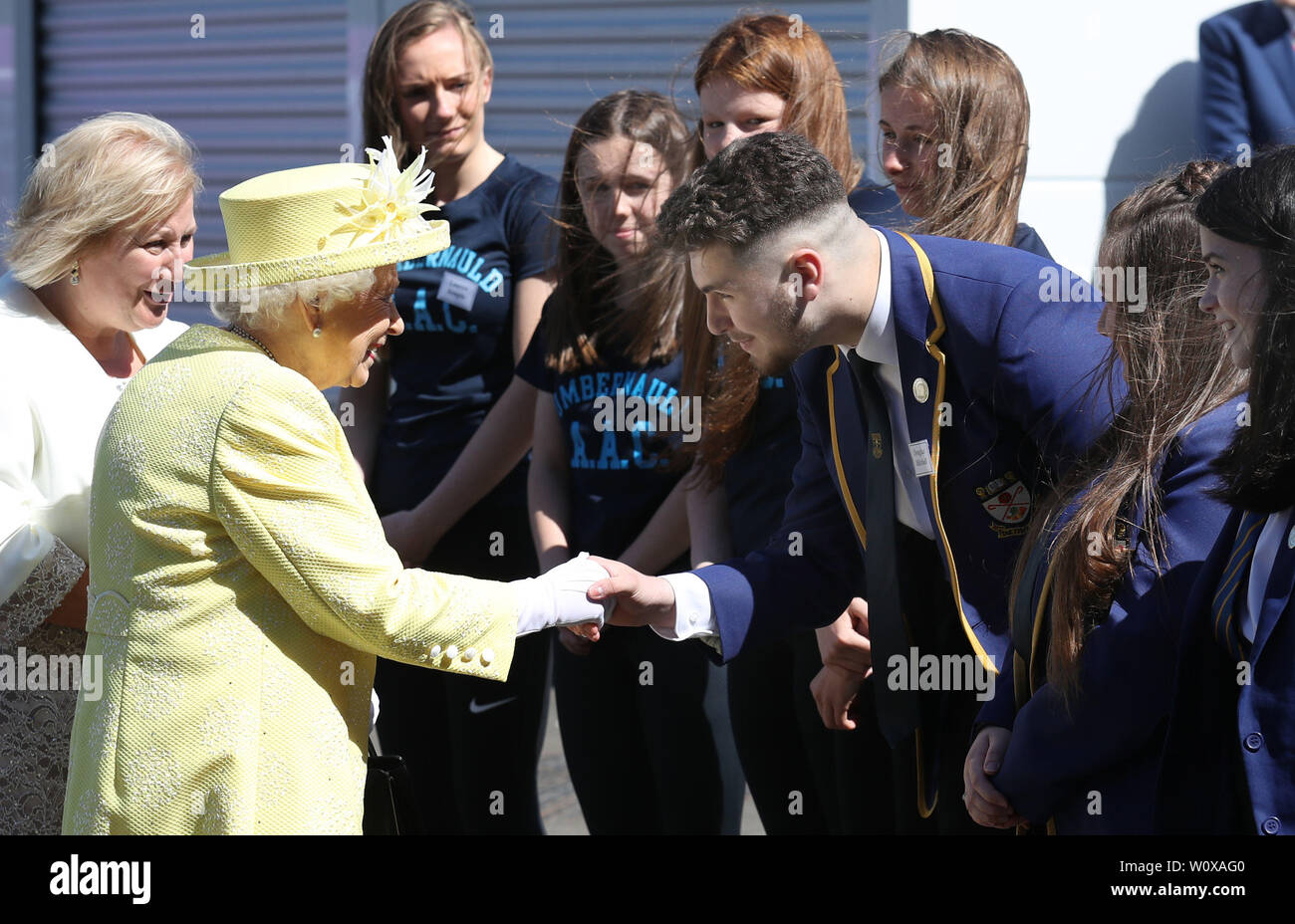 Queen Elizabeth II shakes hands with pupil Douglas Mitchell during a ...