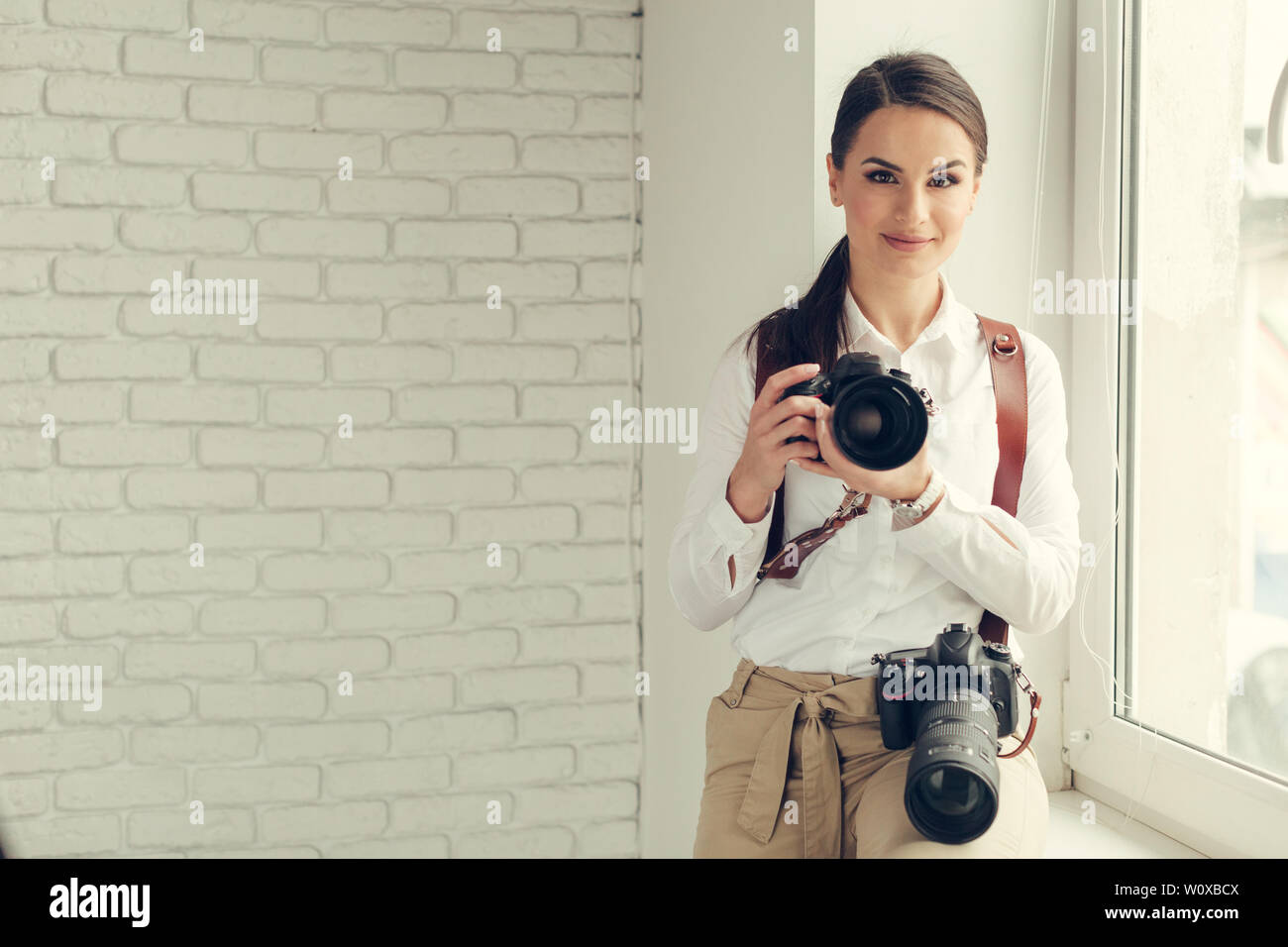 Pretty woman is a professional photographer with dslr camera Stock ...