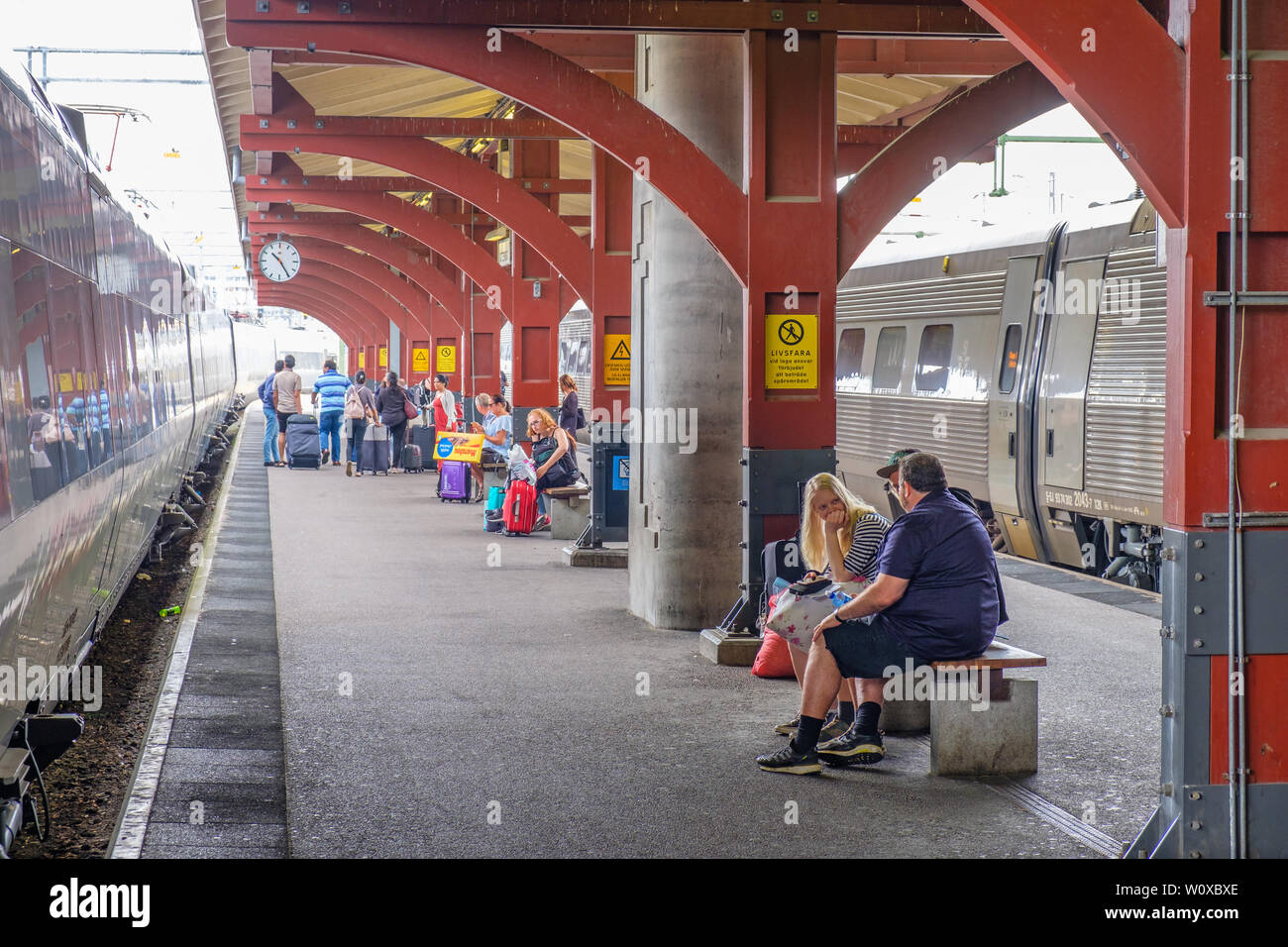 People sitting and waiting to get on the train on a platform Stock ...