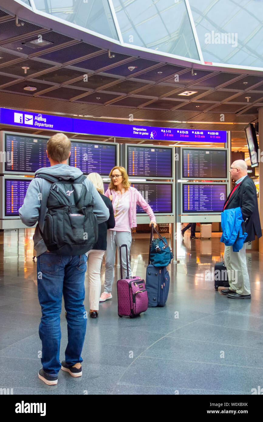 People at a timetable at an airport Stock Photo - Alamy