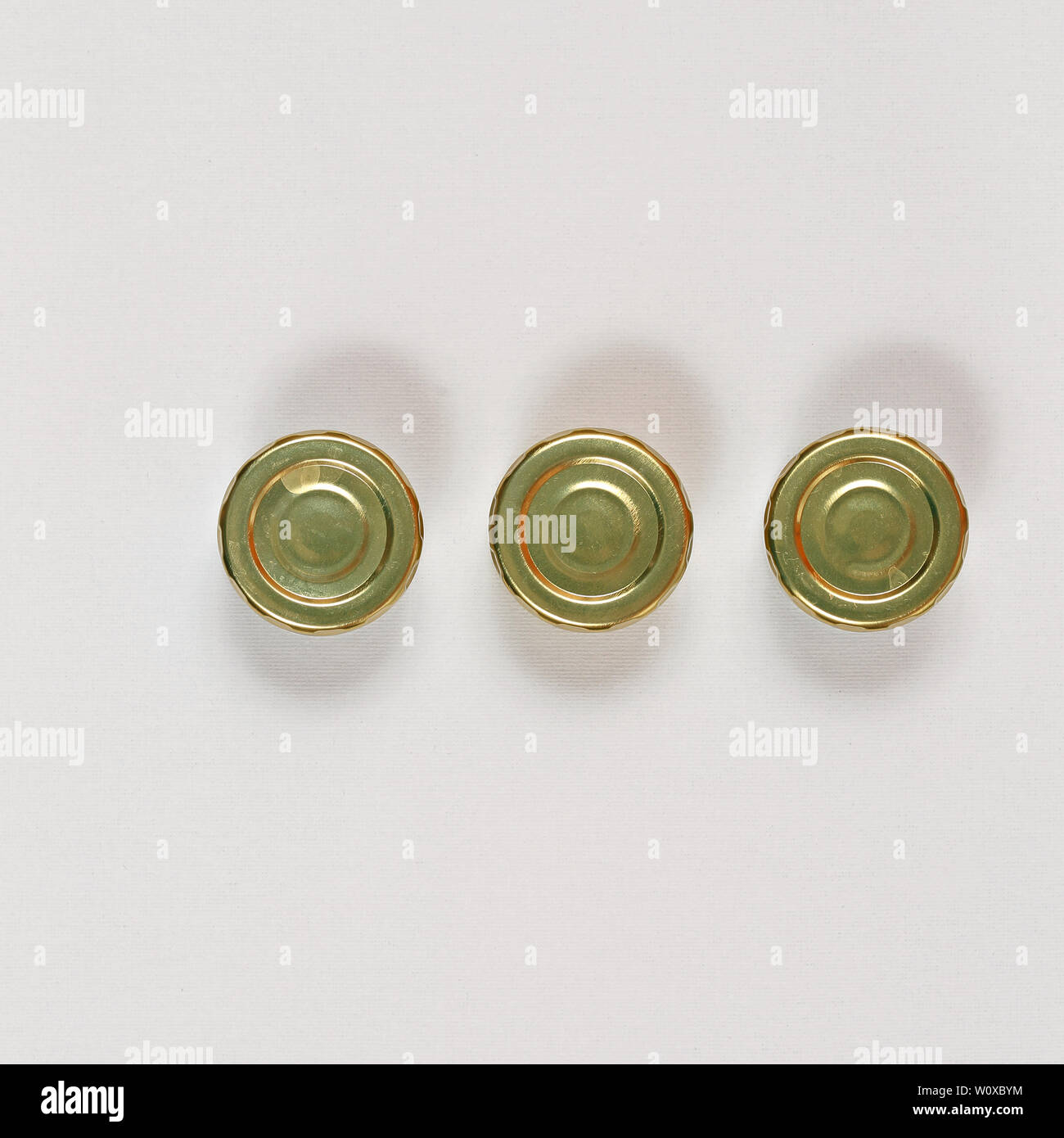 Three Small Jars With Golden Lids Stock Photo - Alamy