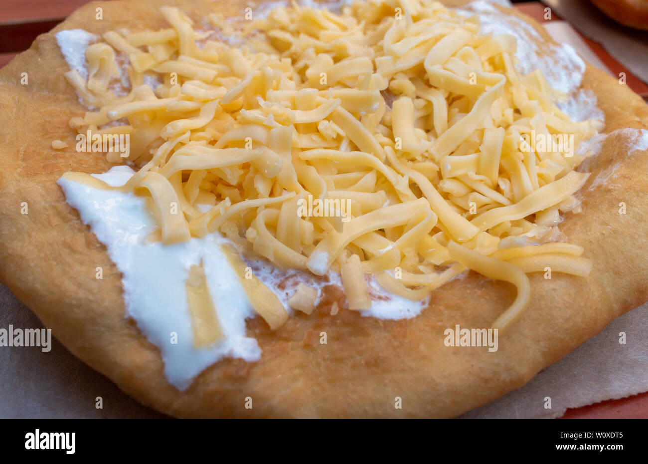 Lángos is a deep fried Hungarian flat bread traditionally topped with ...