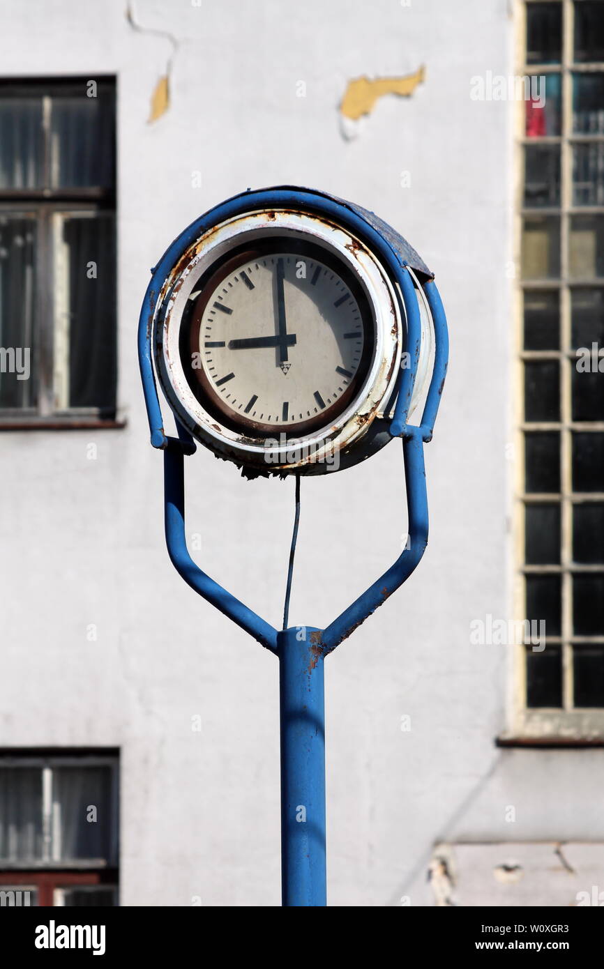 Outdoor analog clock with rusted metal frame in middle of abandoned ...