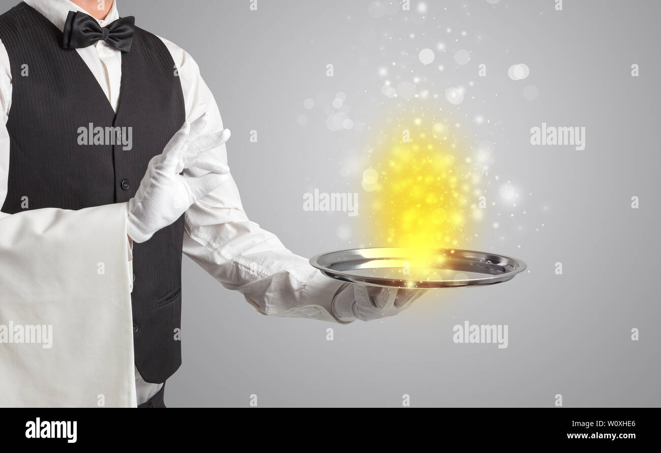 Elegant young waiter serving mysterious light on tray Stock Photo - Alamy
