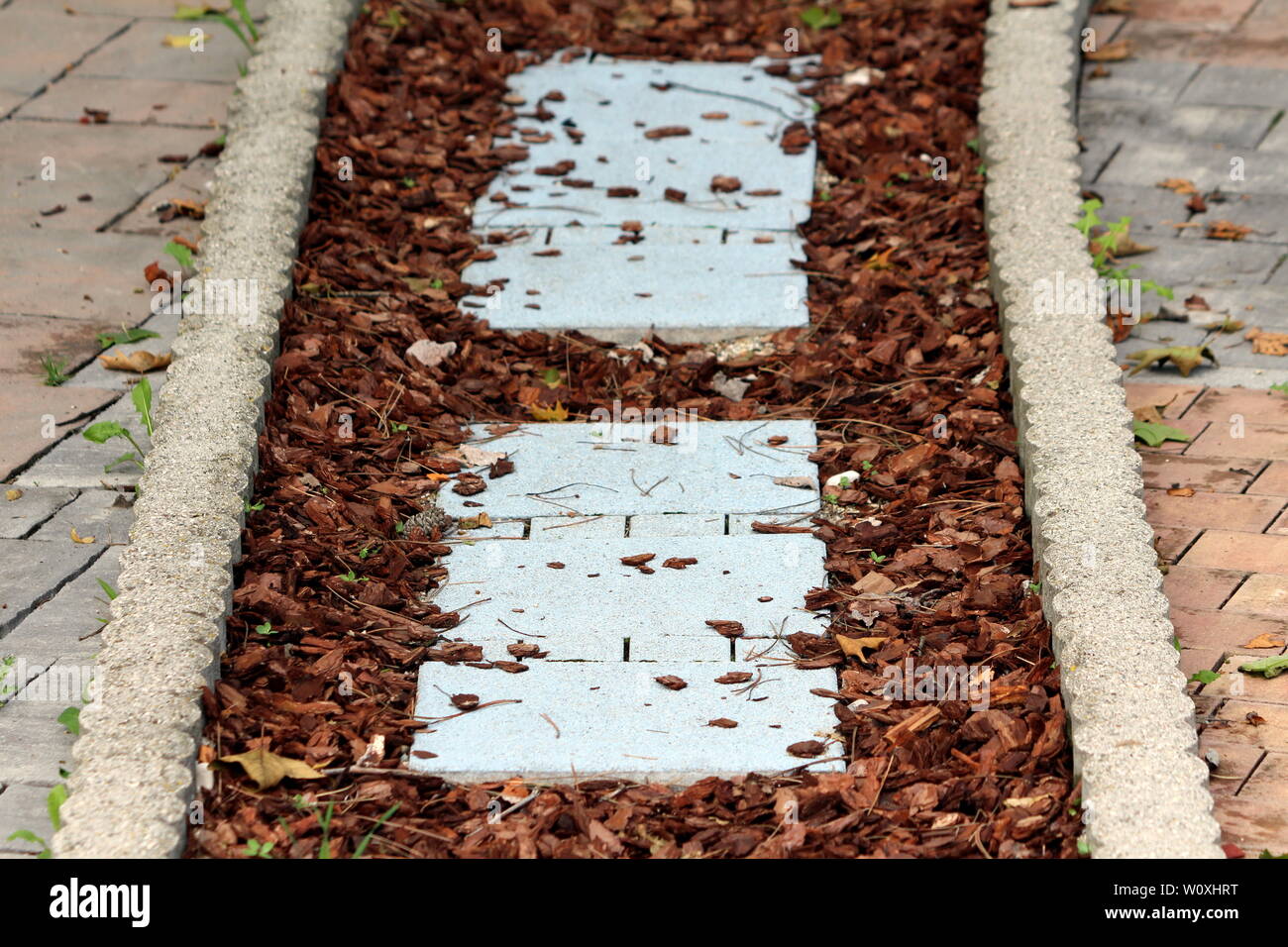 Public park path made of large stone tiles surrounded with decorative ...