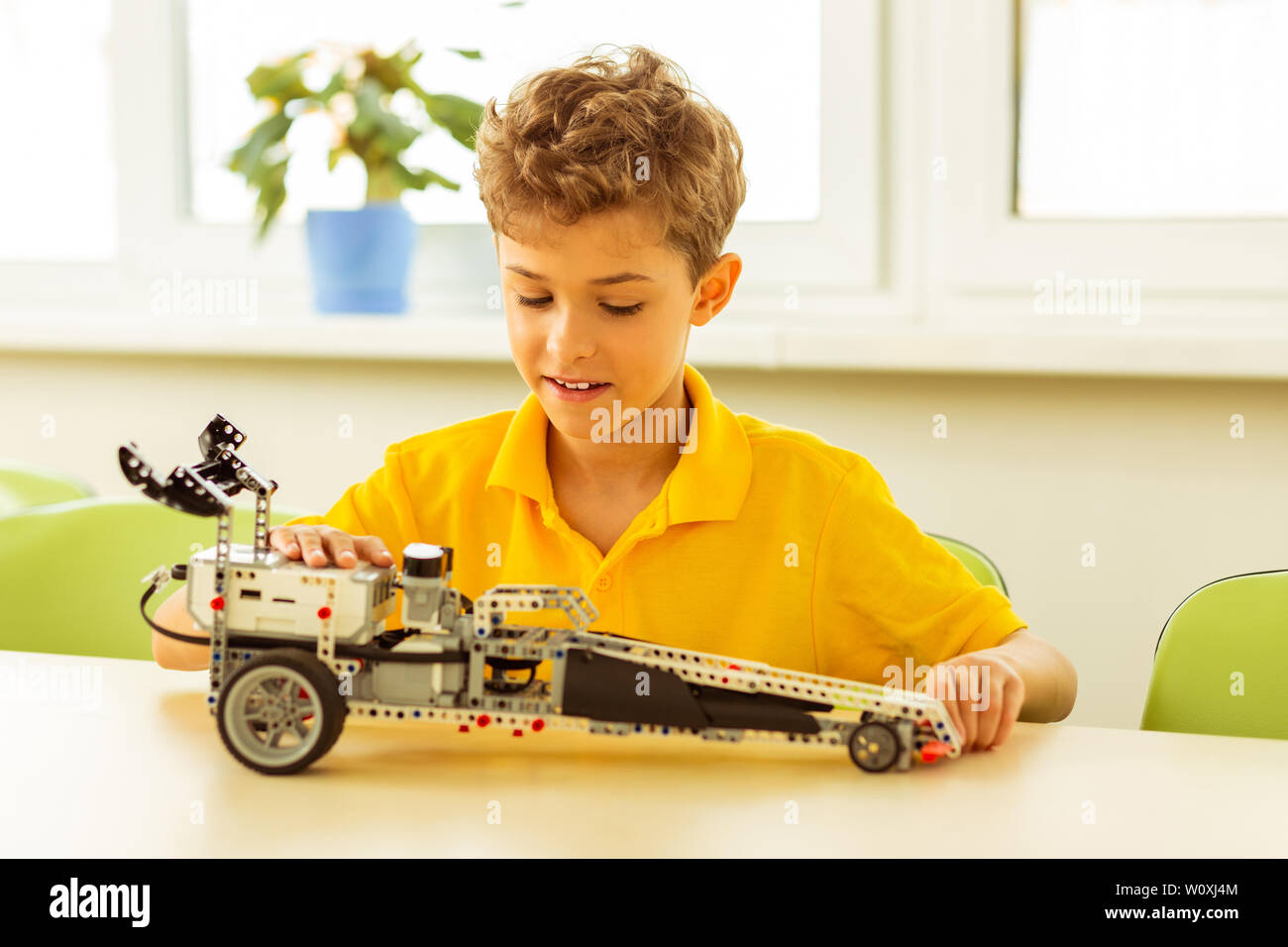 Project preparation. Smart cute boy looking at the car model while ...