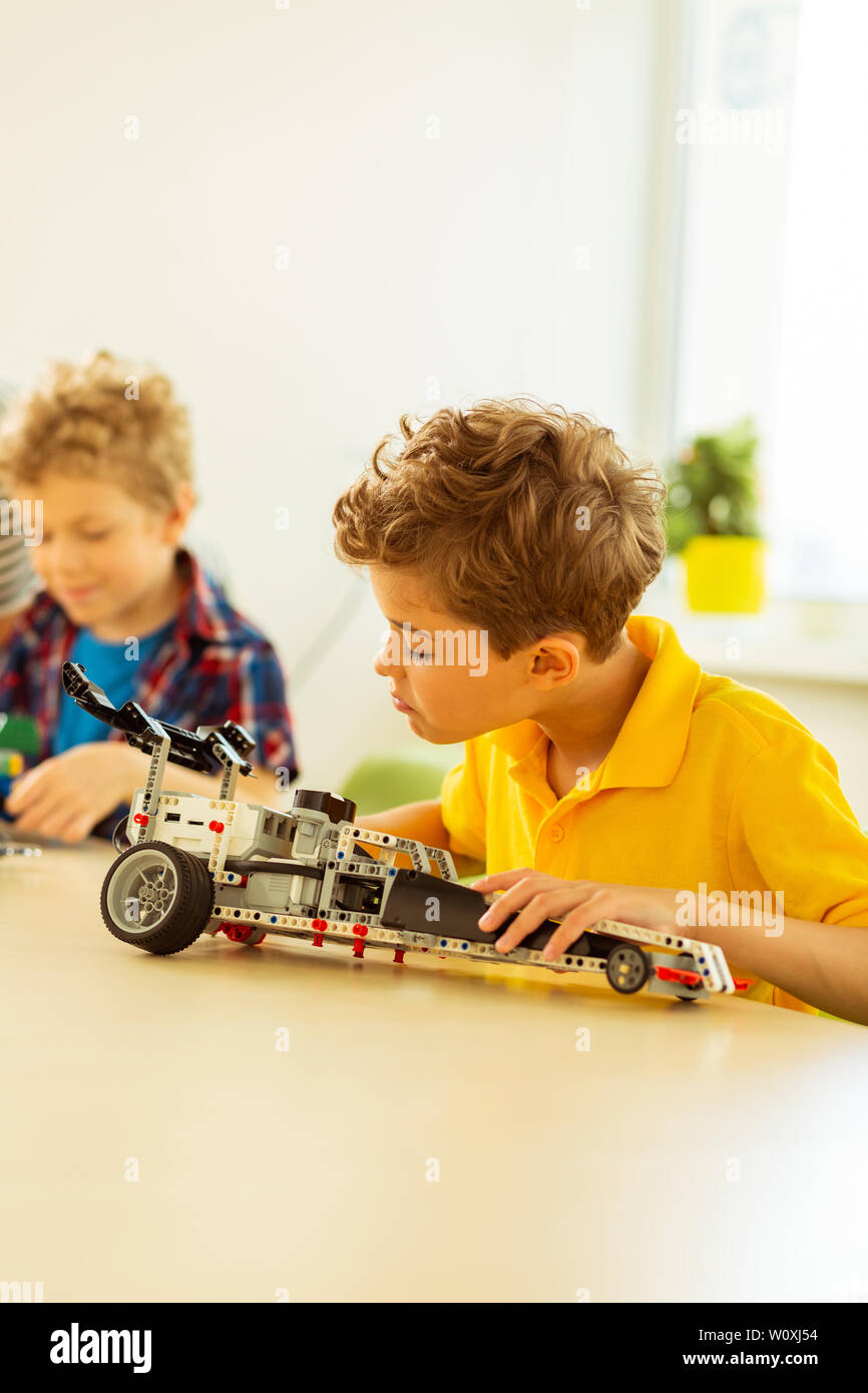 Engineering school. Pleasant young boy sitting at the desk while having ...