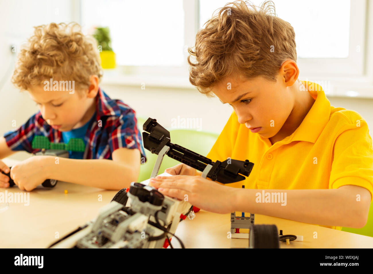 Broken toy model. Smart cute boy trying to understand the problem while ...