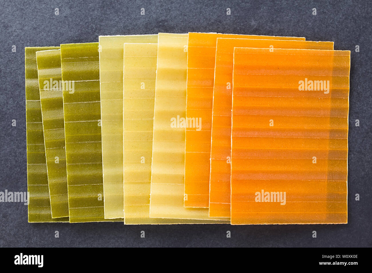 Raw tri color lasagne pasta sheets, photographed overhead on slate ...