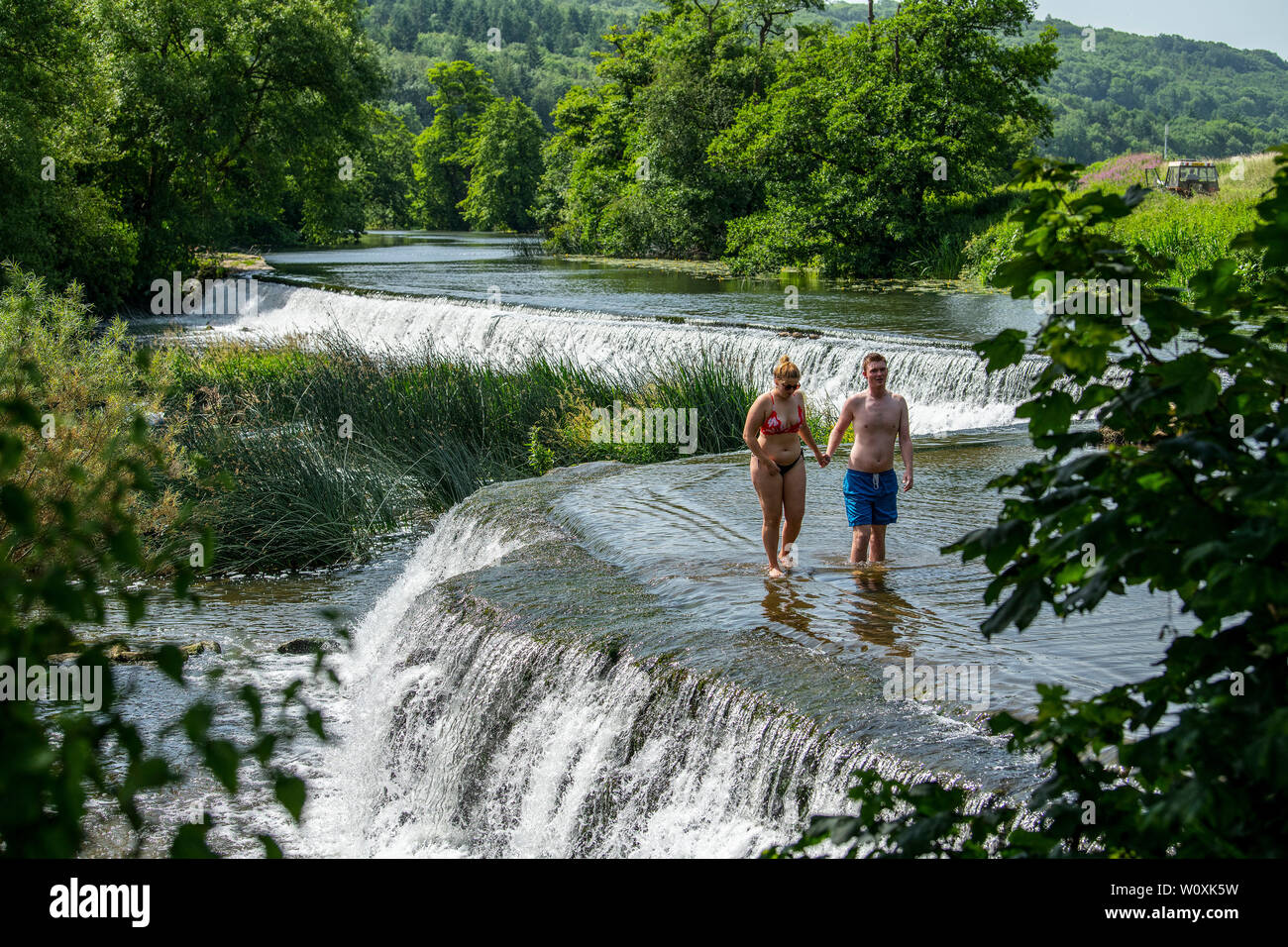 A couple enjoy the water at Warleigh Weir on the River Avon in Somerset ...