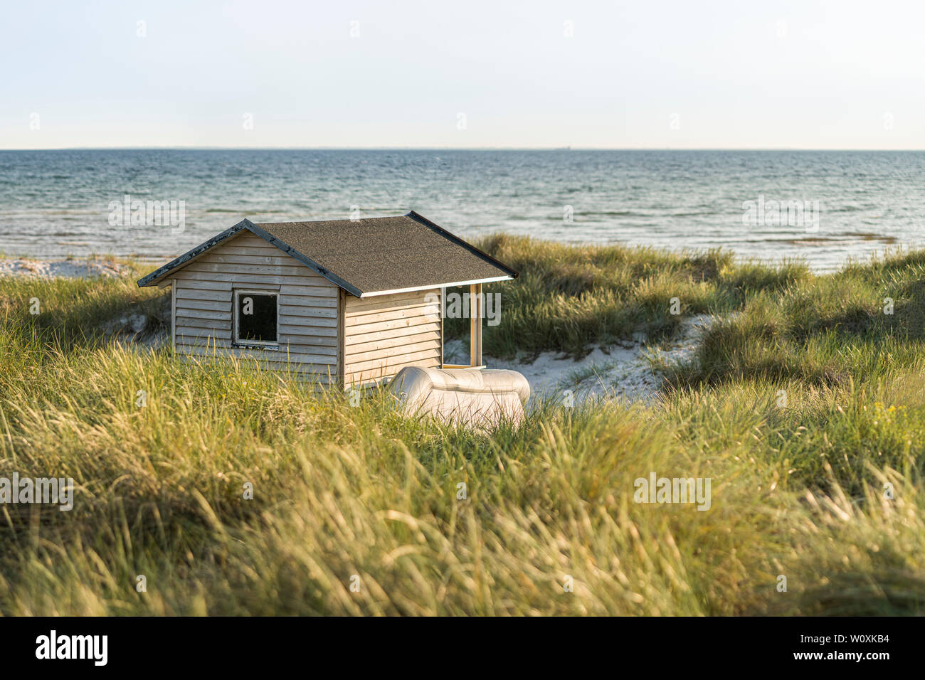 Beach hut and sand dunes at the beach with the sea in the background at ...