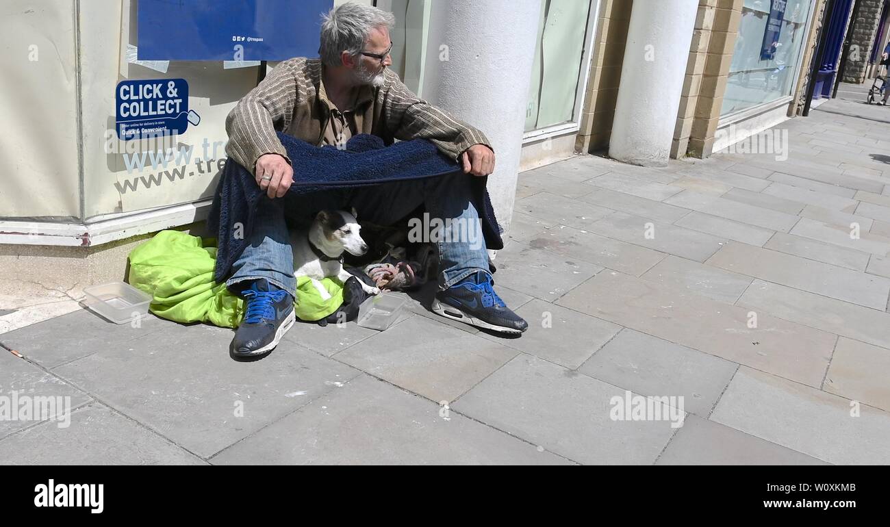 A beggar sits outside a shop in Buxton, Derbyshire Stock Photo - Alamy