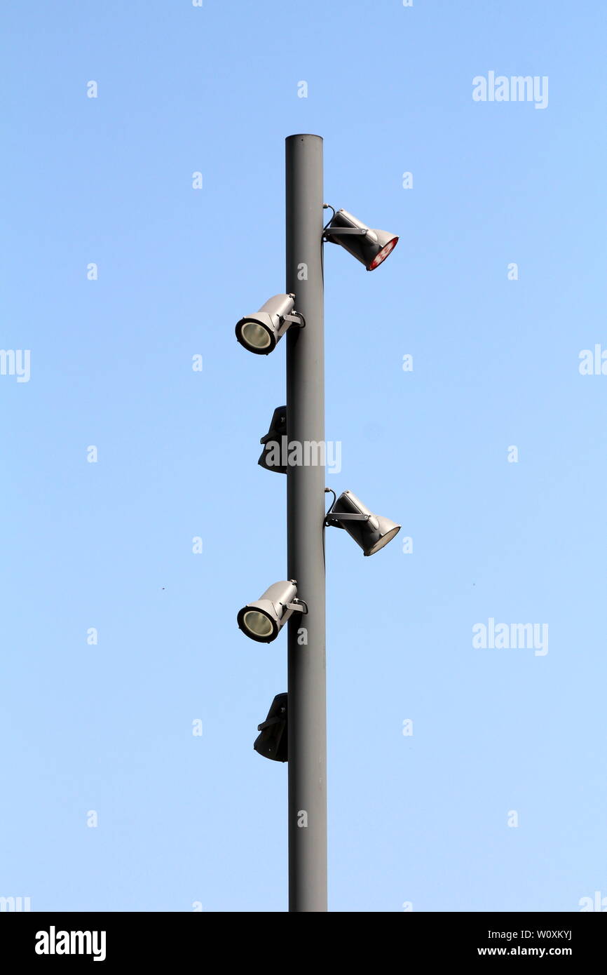 Tall strong metal pole with multiple light reflectors mounted on all ...