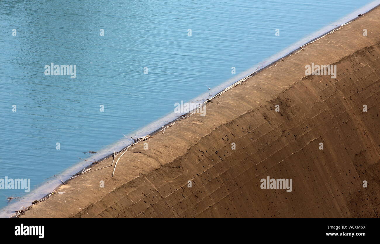Top of small old concrete dam during dry season with water at the very ...