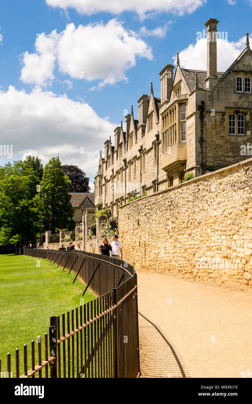 The back of Merton College brightly sunlit under a blue sky with white ...