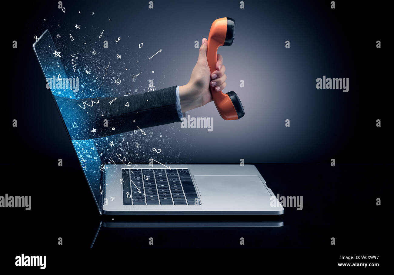 Hand with vintage phone coming out of a laptop with sparkling effects ...