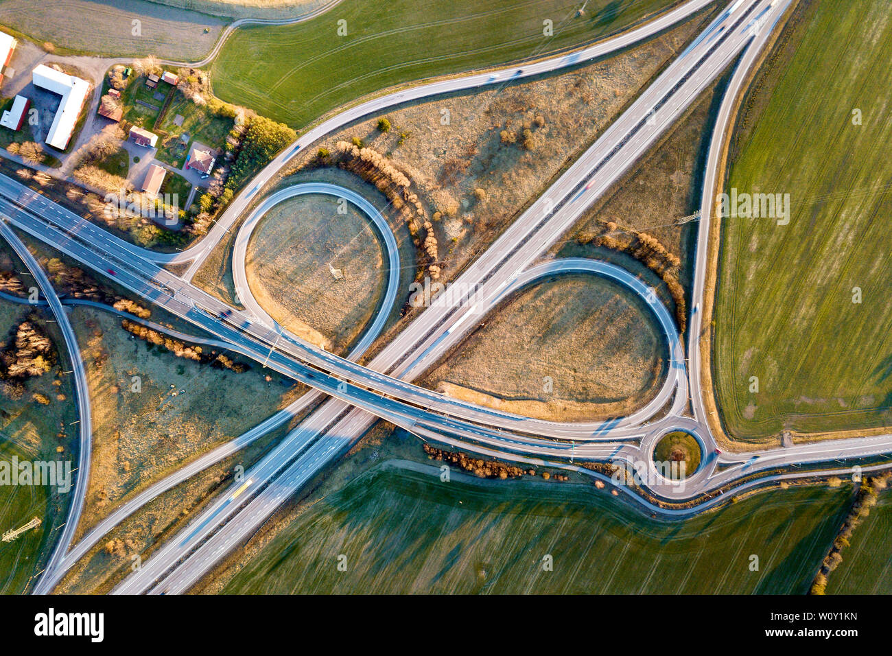Aerial top view of modern highway road intersection, house roofs on ...