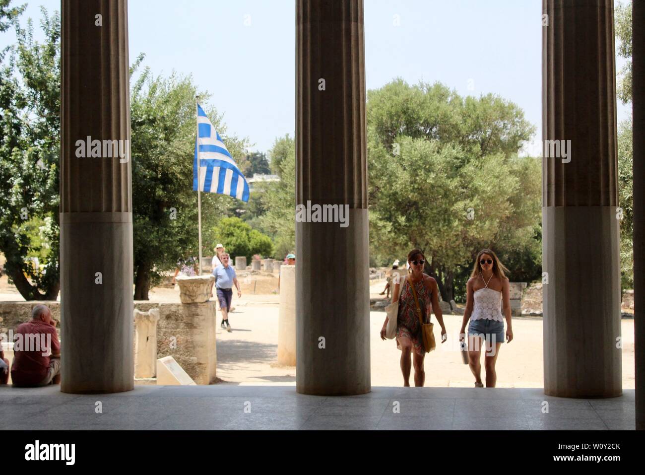 Ancient Agora of Athens two women near pillars and greek flag greece ...