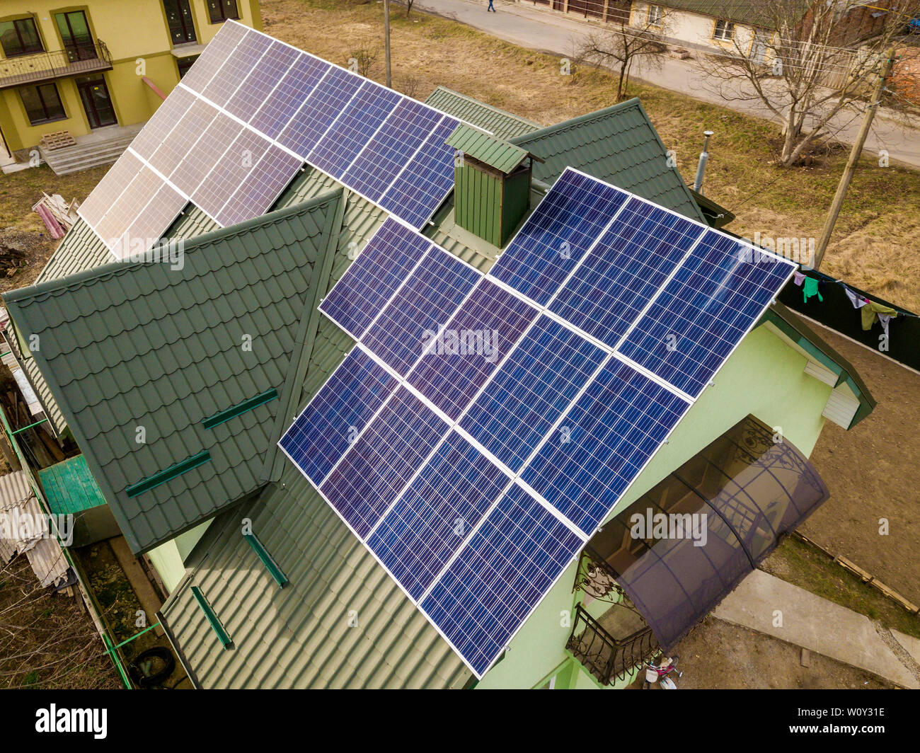 Aerial view of house cottage with blue shiny solar photo voltaic panels ...