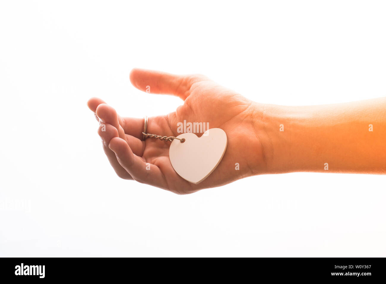 Heart shaped white object in hand on white background Stock Photo - Alamy