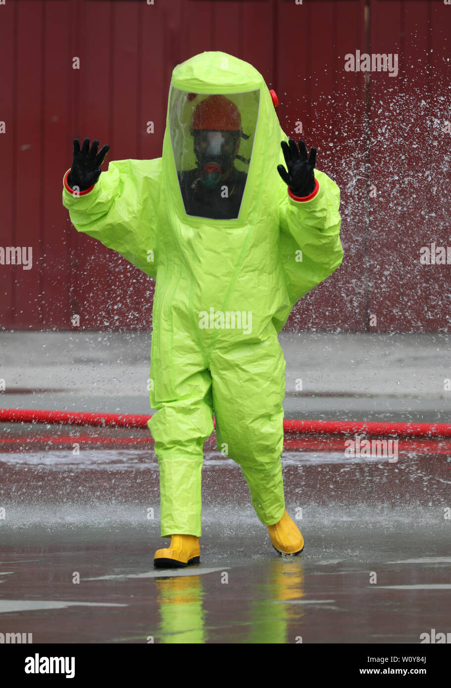 fireman wears a fluorescent protective suit to extinguish a fire caused ...