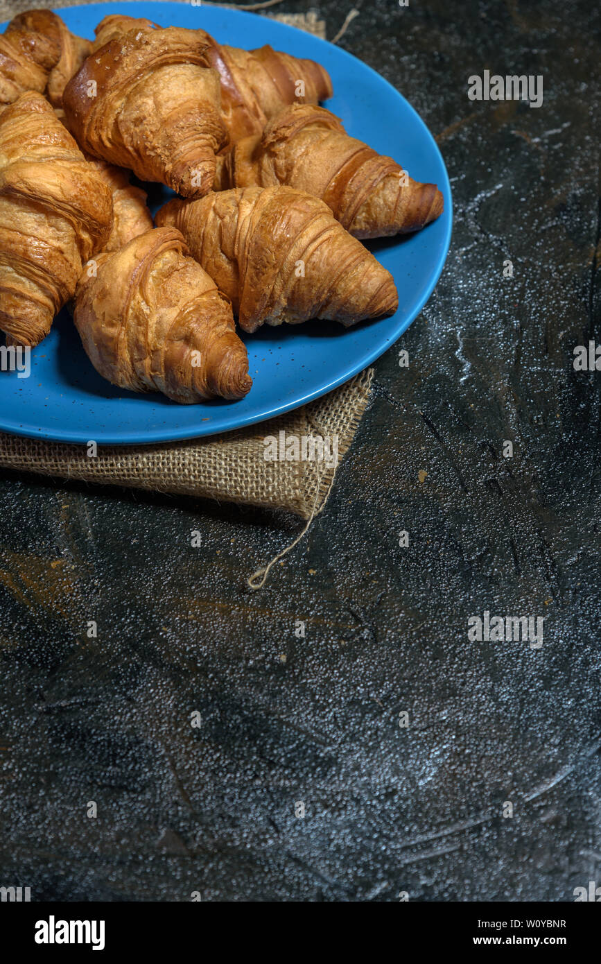 Freshly made croissants served a blue plate Stock Photo - Alamy